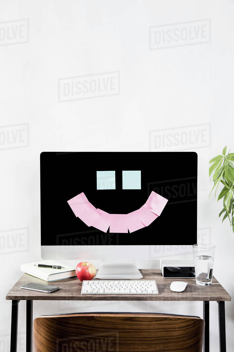 Adhesive notes forming smiley face on computer in office - Stock Photo ...