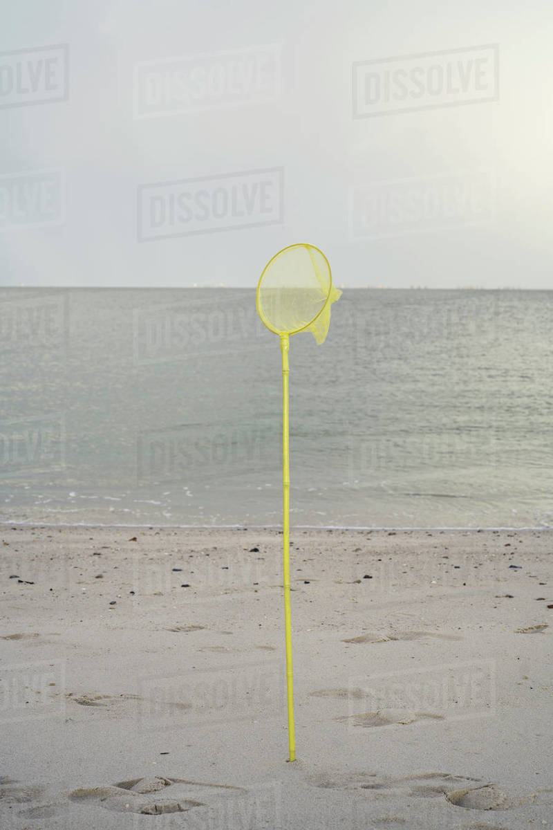 Yellow fishing net in sand on ocean beach - Royalty-free Stock Photo ...