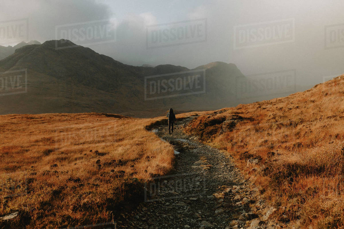 Hiker on trail at sunset in remote Scottish Highlands, Scotland - Stock ...