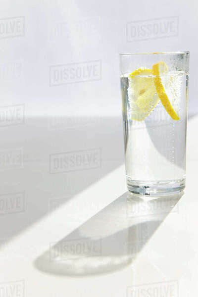 Glass of sparkling water with sliced lemon - Stock Photo - Dissolve