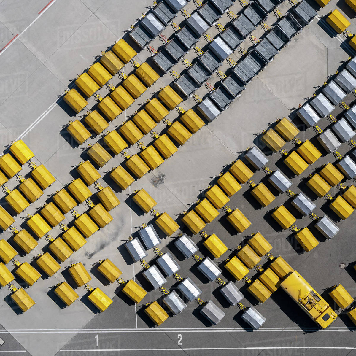 View from above empty yellow and black luggage carts on sunny airport ...