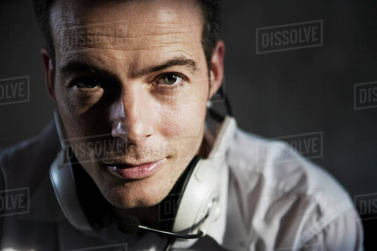A man wearing a headset around his neck, close-up - Stock Photo - Dissolve