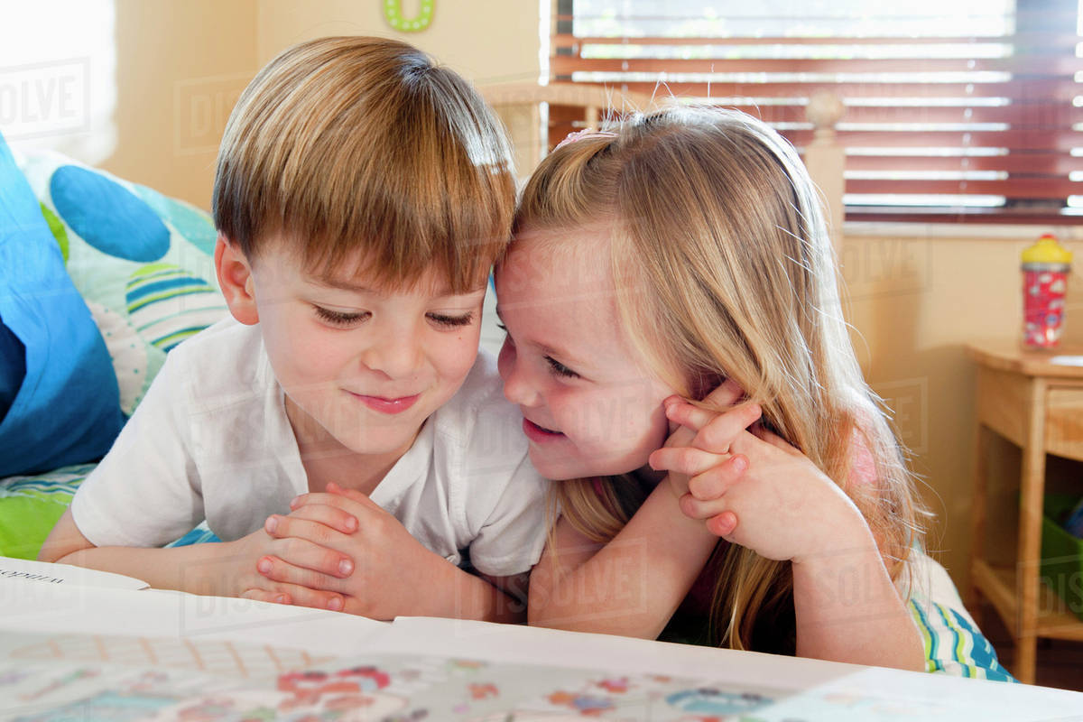 A boy and a girl reading a book together - Royalty-free Stock Photo ...