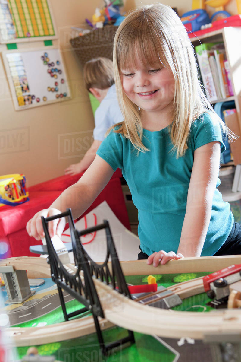 A girl playing with a train set - Royalty-free Stock Photo | Dissolve
