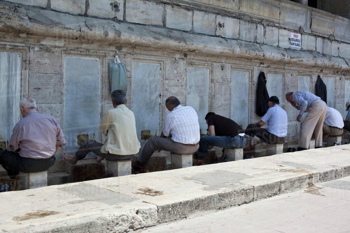 Muslim men wash their feet before praying in The New Mosque, Istanbul ...