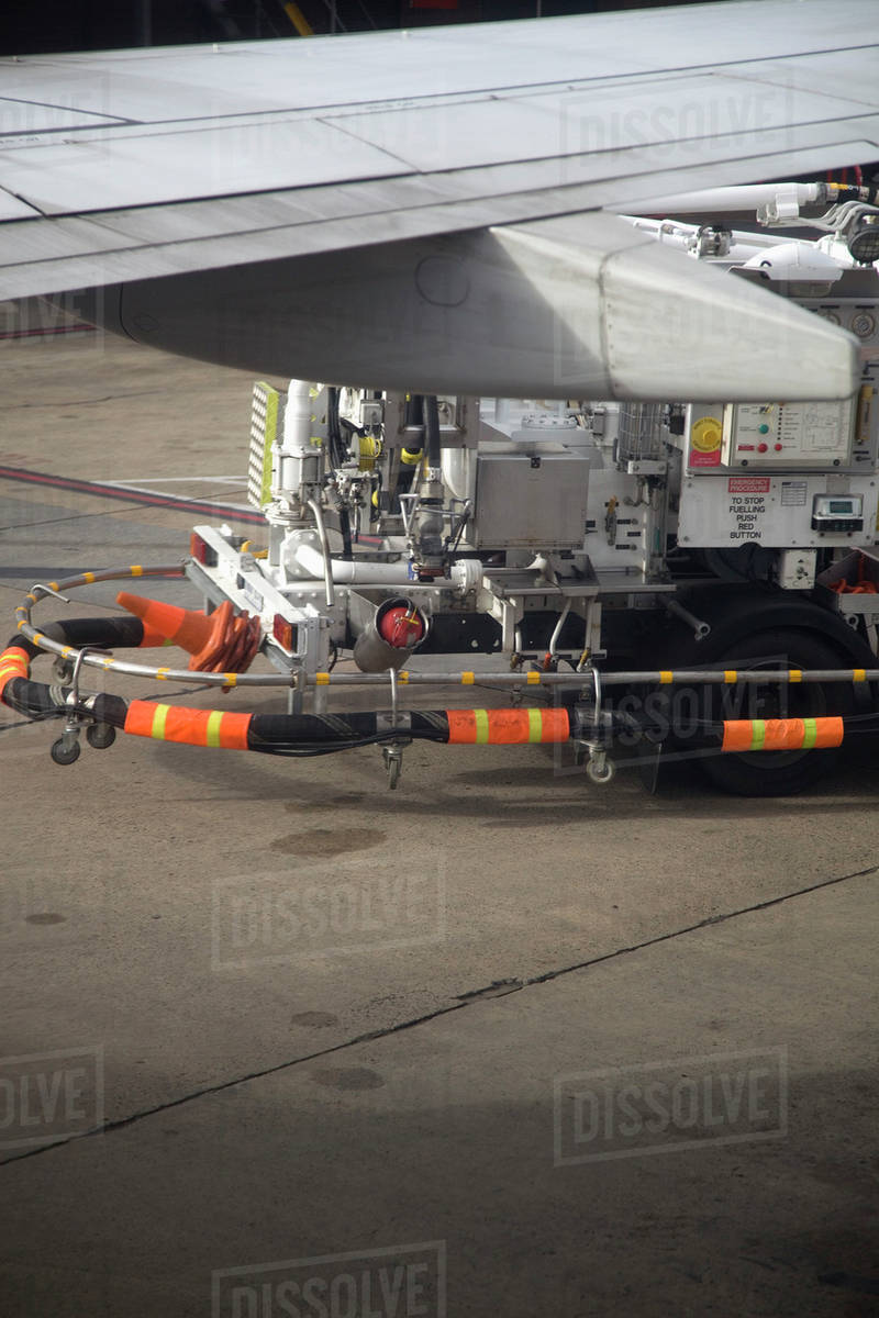 Airplane wing and airport land vehicle - Stock Photo - Dissolve